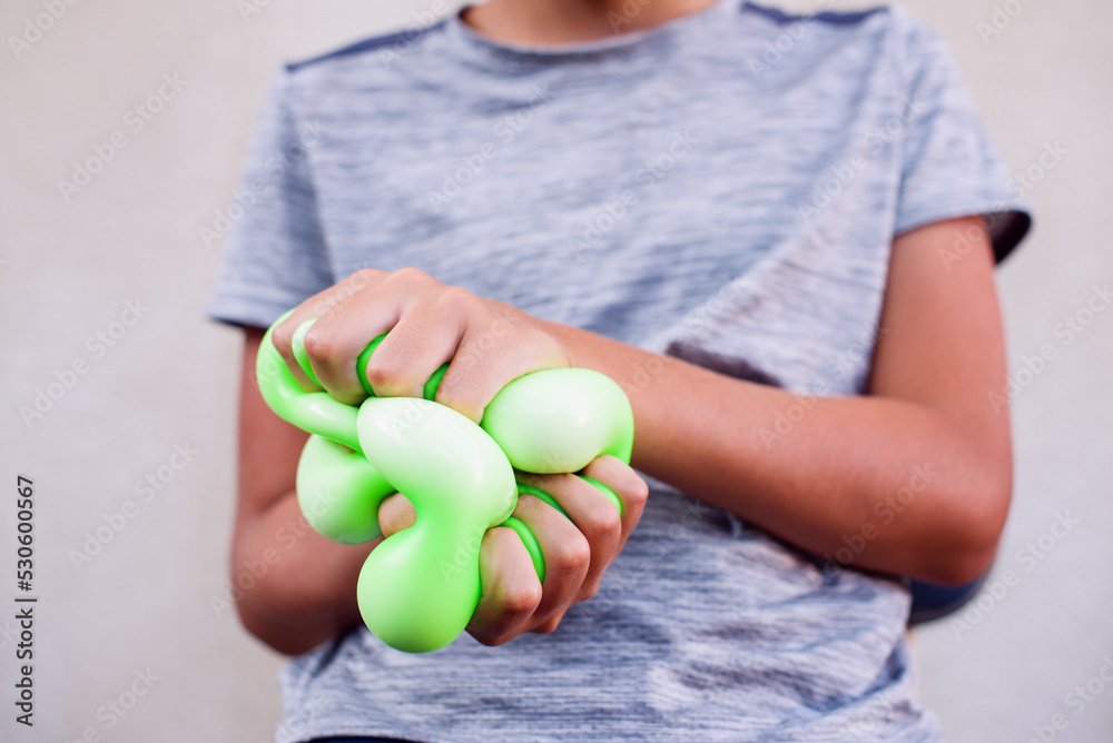 Teen boy playing with anti stress sensory ball squeeze toy. Giant ...
