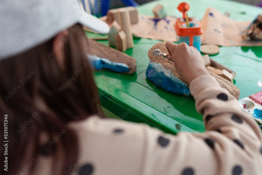 kid is making a lighthouse with an island from driftwood, a child is ...
