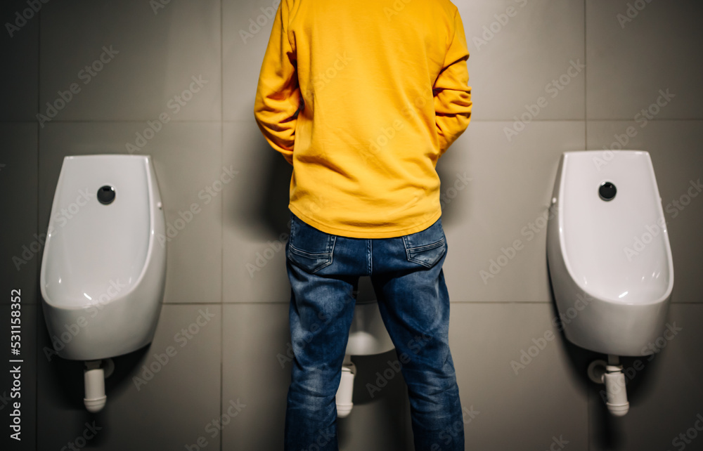 Man peeing to toilet bowl in restroom Stock Photo | Adobe Stock