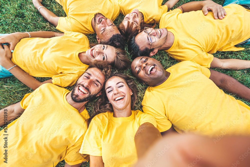 Multiracial community of young people smiling together at camera ...