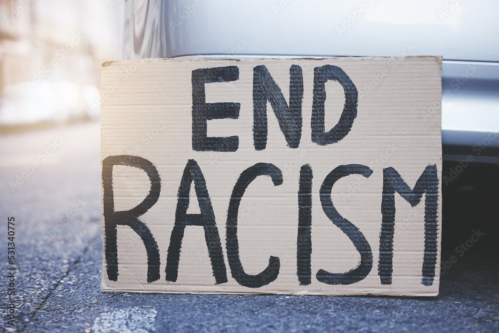 End racism placard, sign and poster for protest in an urban street ...