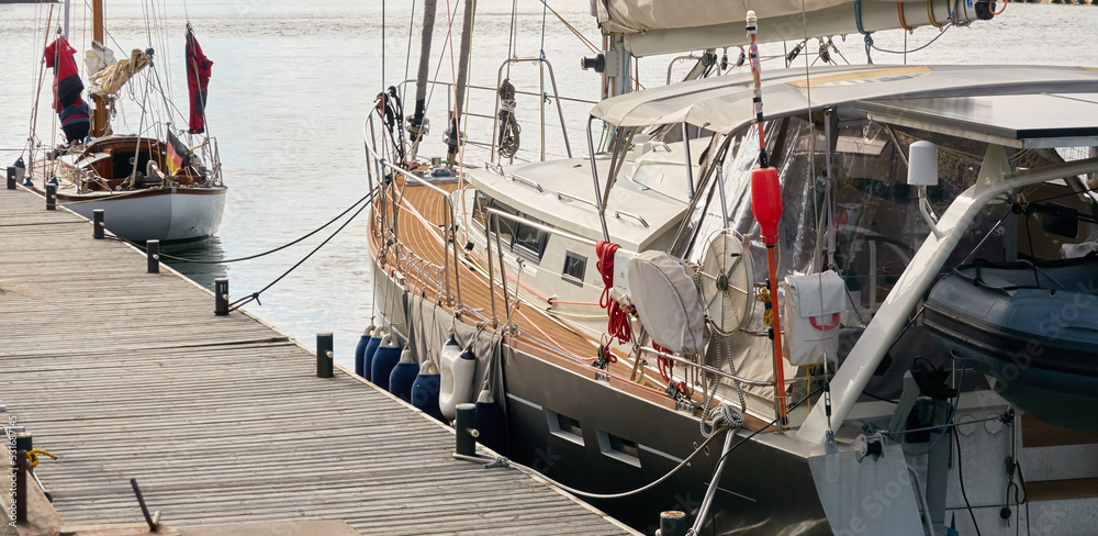 Modern aluminum exploration sailboat moored to a pier in a yacht marina ...