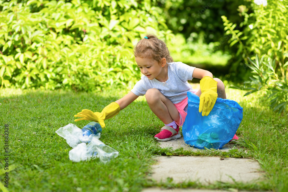 Girl collection plastic garbage in nature. kid picking up trash in park ...
