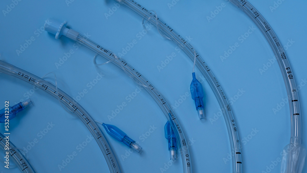 endotracheal tubes of different sizes and diameters lie on a light blue ...