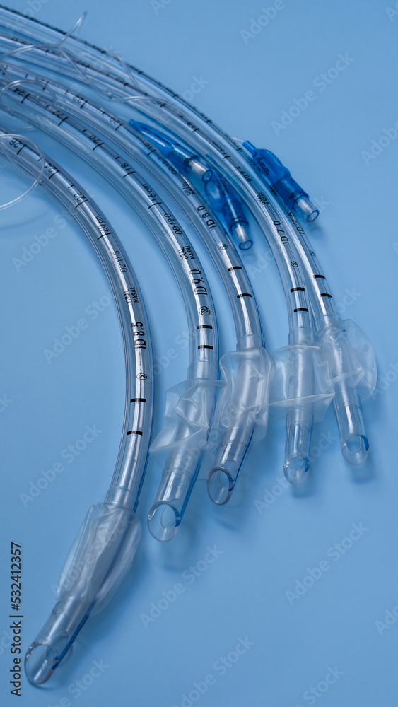 endotracheal tubes of different sizes and diameters lie on a light blue ...