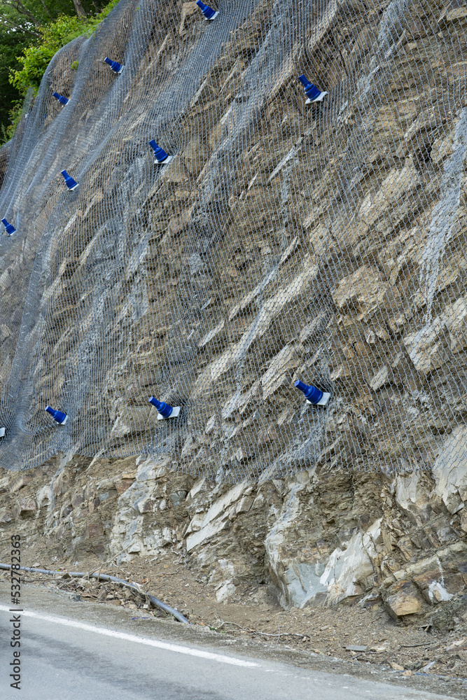 Foto de Stock Reinforcing mountain slope with metal mesh and concrete ...