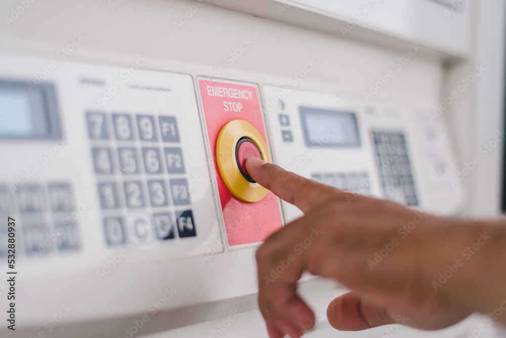 Person touching the emergency stop button Stock Photo | Adobe Stock