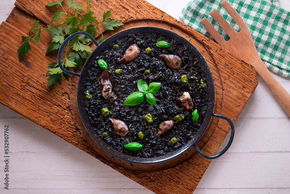 Black paella with squid and pistachio pesto. Tapa paella typical recipe ...