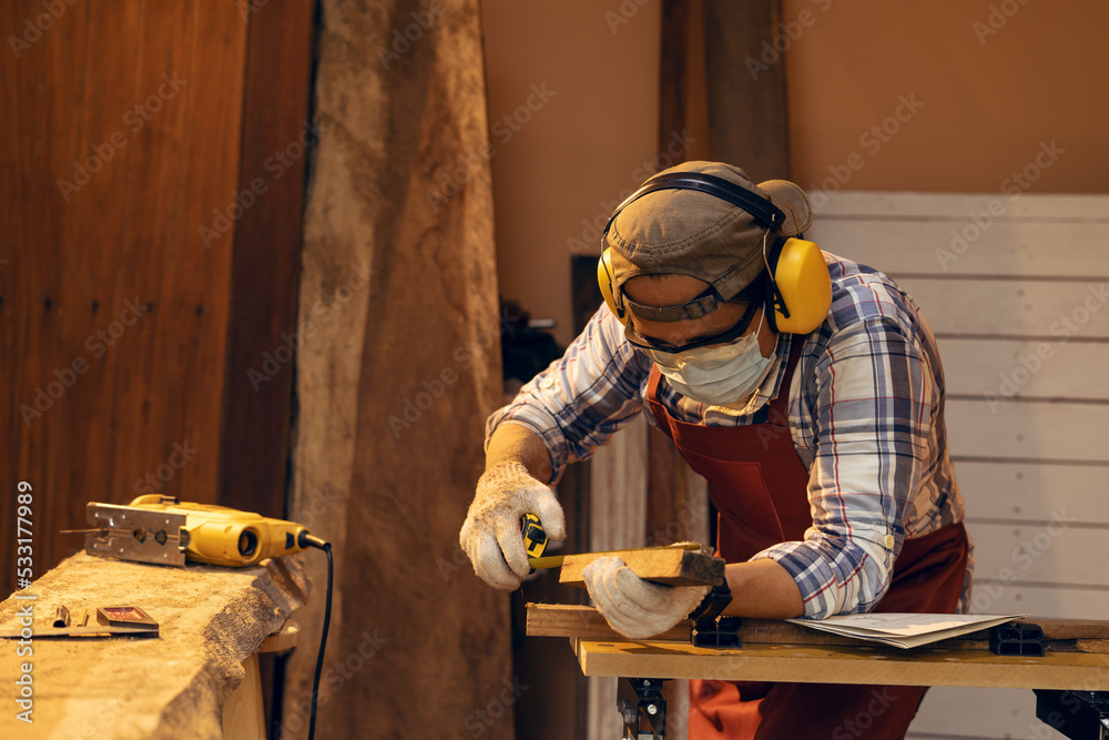 Asian man Carpenter wearing PPE working use measuring tape marking on ...
