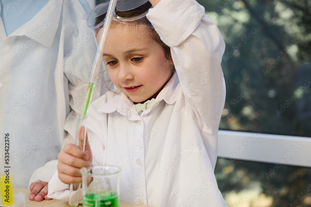Smart Caucasian schoolgirl, elementary age student wearing white lab ...