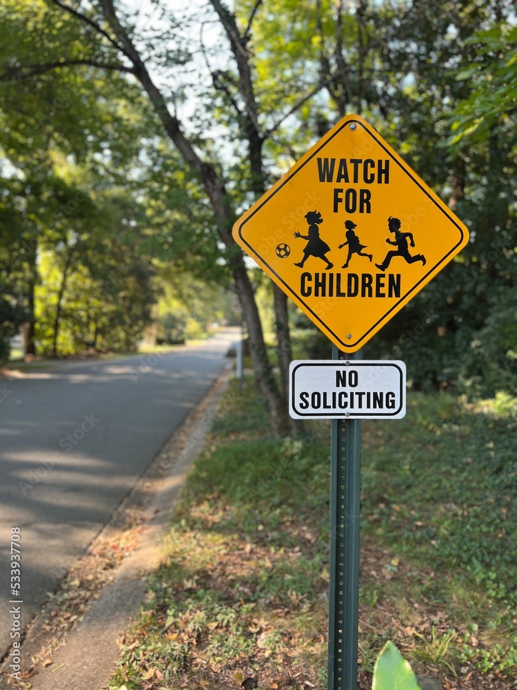 Yellow caution watch for children sign and no soliciting sign in a ...