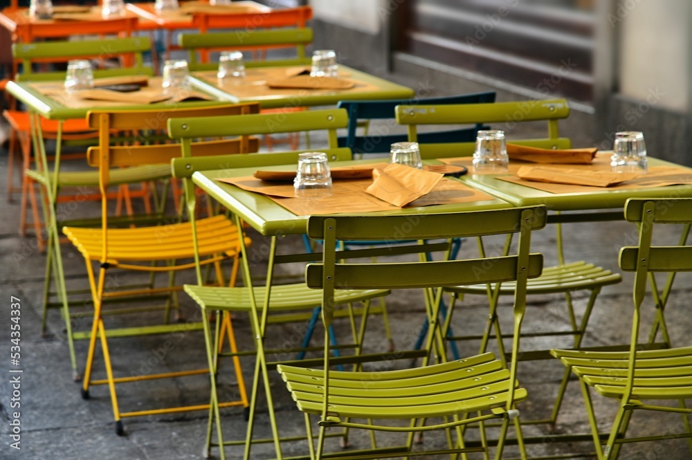 Empty restaurant tables set in the terrace waiting customers for dinner ...