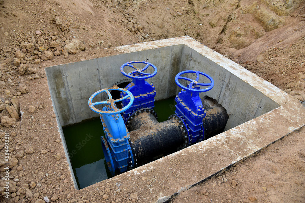 Sewer construction. Gate valves in valve pit of underground piping ...