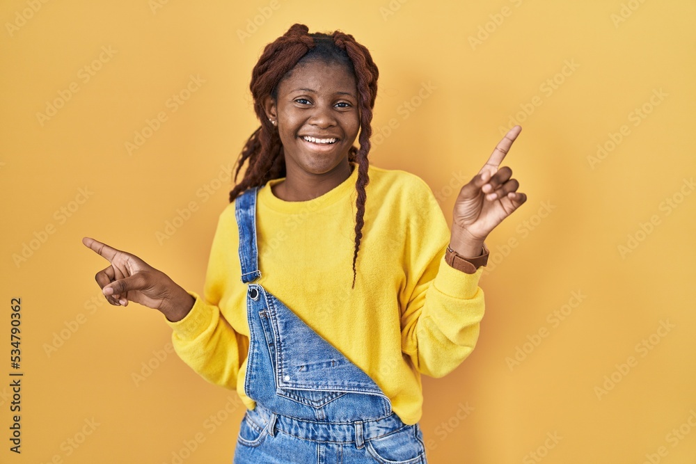 African woman standing over yellow background smiling confident ...