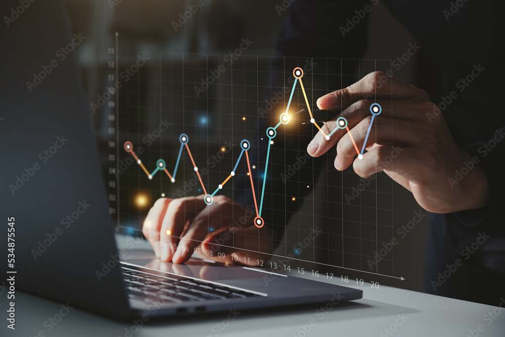 Businessman using computer with graph growth analysis on virtual screen ...