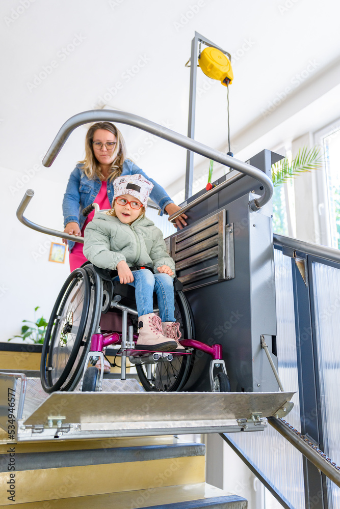 Mother with a young child living with cerebral palsy using electric ...
