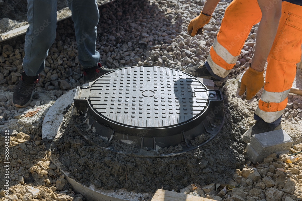 An cast iron sewer hatch in concrete base for installation of sewer ...