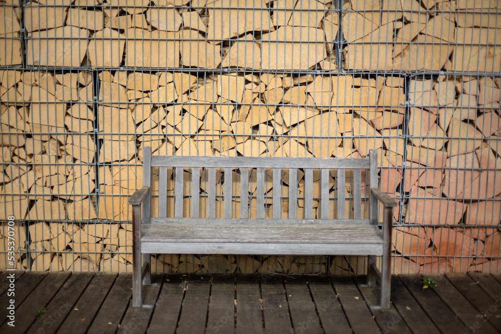 Photo Stock Wooden bench in front of yellow stone brick wall with metal ...