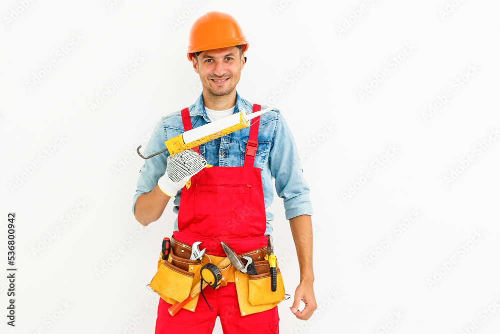 construction worker plasterer man uses caulking gun in building site of ...
