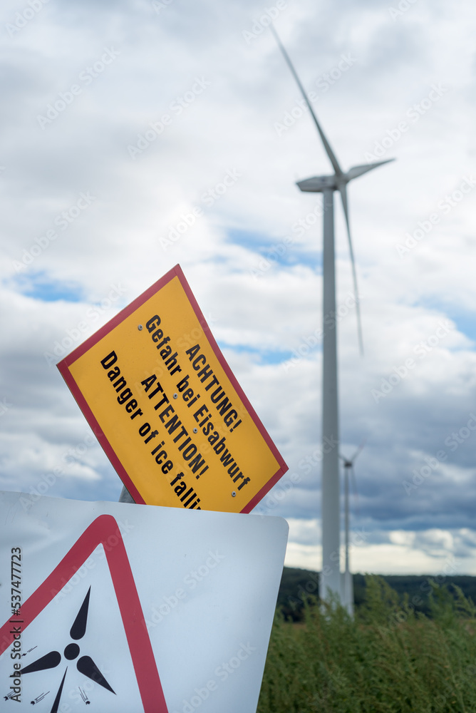 Wind Turbines with a caution sign warning of the dangers of approaching ...