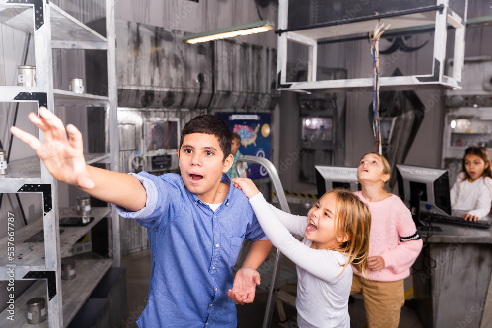 Little girl yelling at boy reaching for something in closed quest room ...