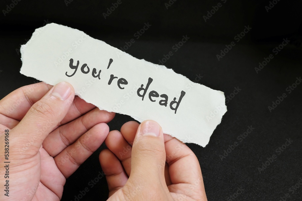 Death threat concept. Human hands holding a paper note with written ...