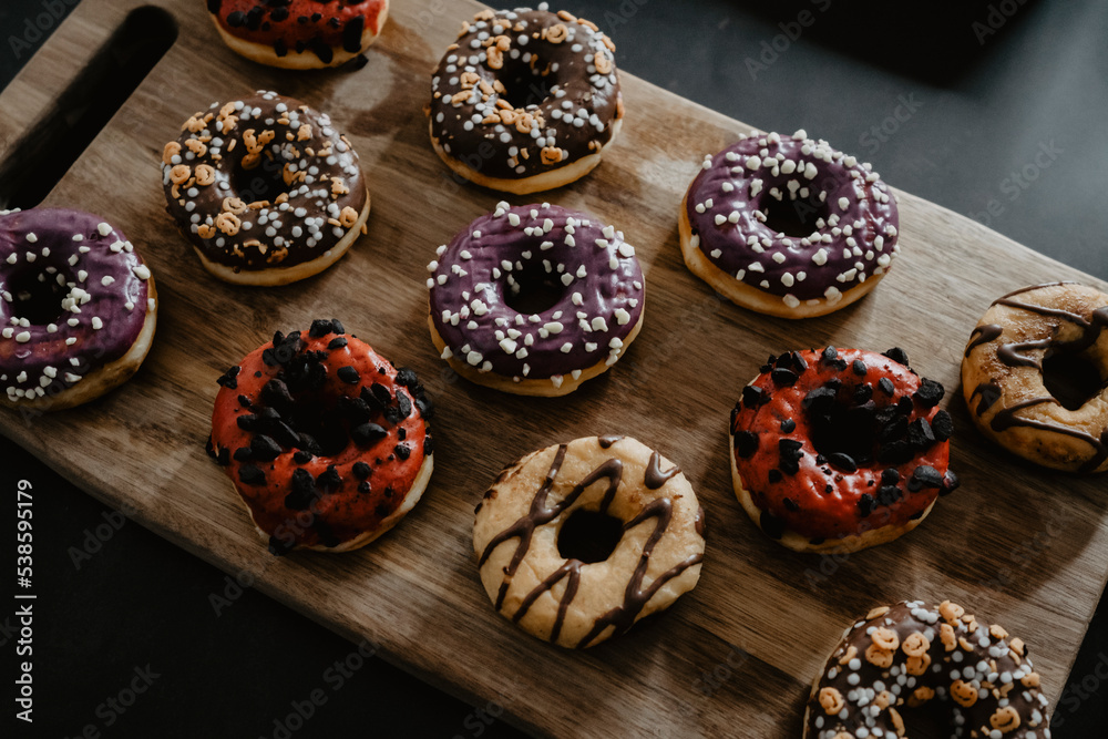 conjunto de donuts de diferentes colores con chocolate y azúcar encima ...