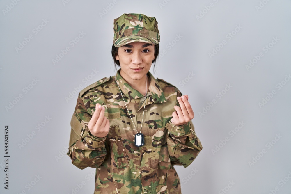 Young south asian woman wearing camouflage army uniform doing money ...