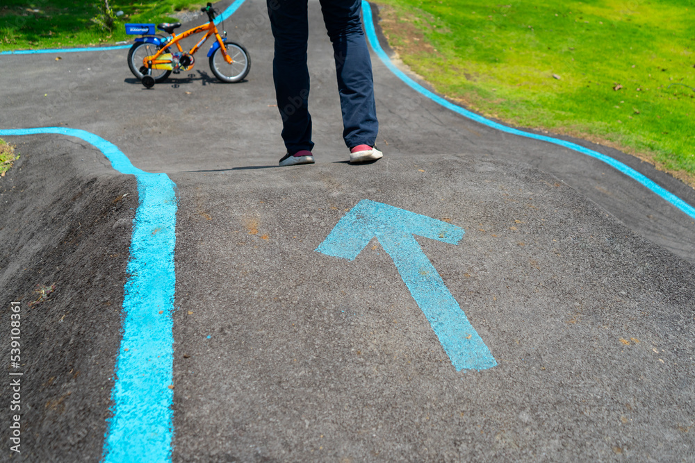 Kid walk on off-road cycling course with arrow to give directions with ...