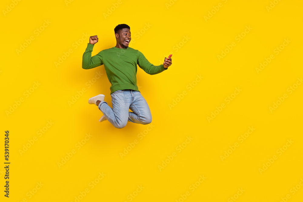 Full length body size view of handsome trendy guy using device jumping ...