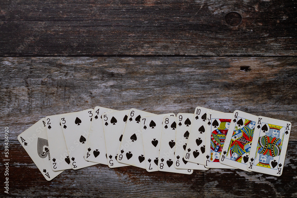 Row of old playing cards, face up showing the suit of spades in order ...