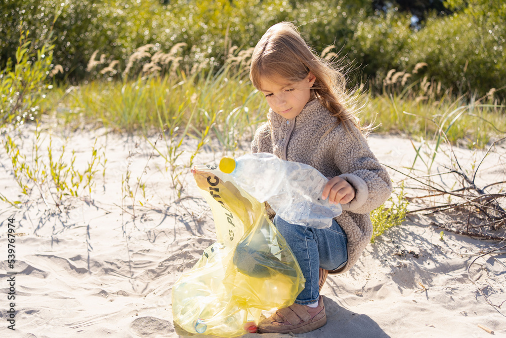 Photo Stock little girl with trash bag cleaning up the beach. Child ...