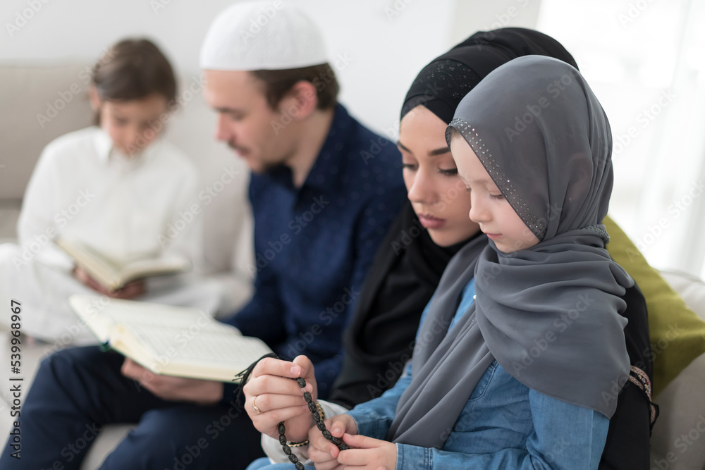 Traditional muslim family parents with children reading Quran and ...
