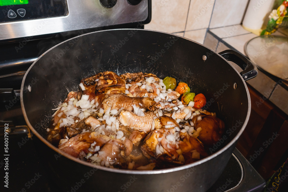 Imagen horizontal de una olla sobre la estufa llena de trozos de pollo ...
