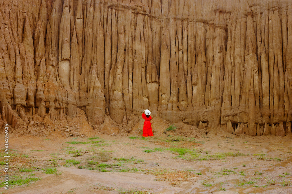 Women and landscape of soil textures eroded sandstone pillars, columns ...