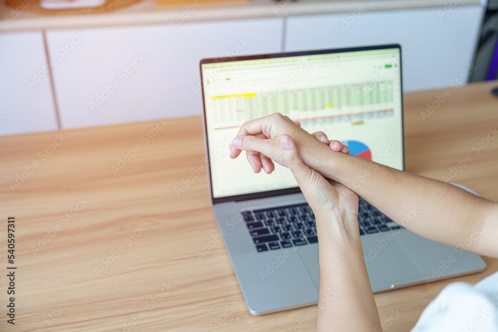 Woman having wrist pain when using laptop computer and mouse during ...