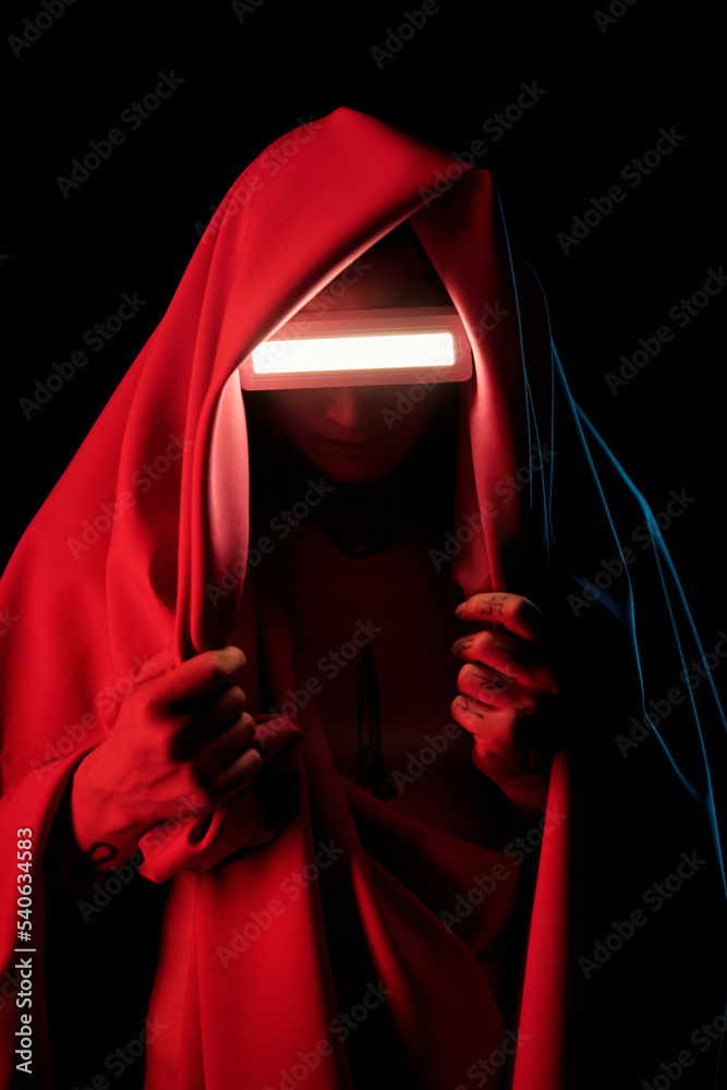 Portrait of man in red mantle with innovation glasses standing against ...