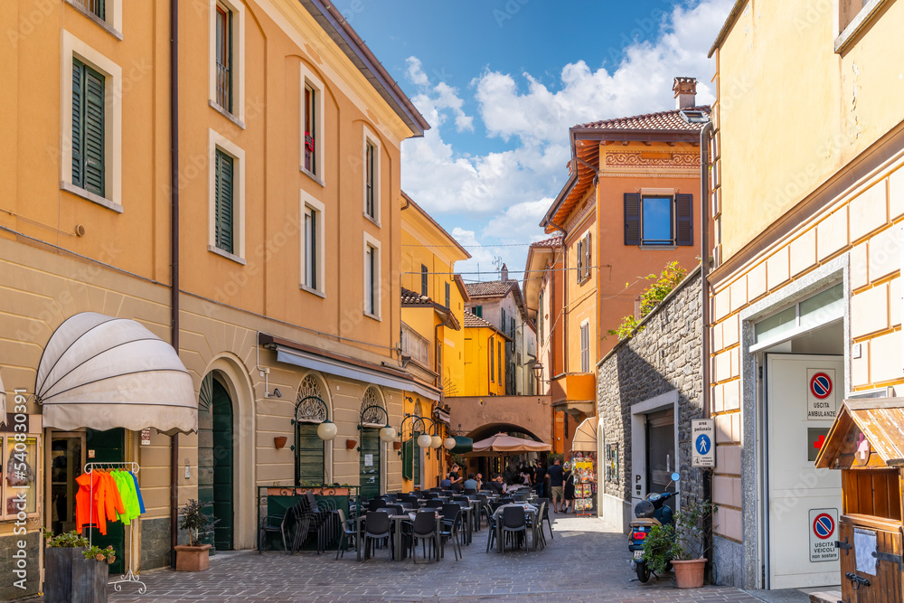 A narrow side street of shops and sidewalk cafes in the colorful ...