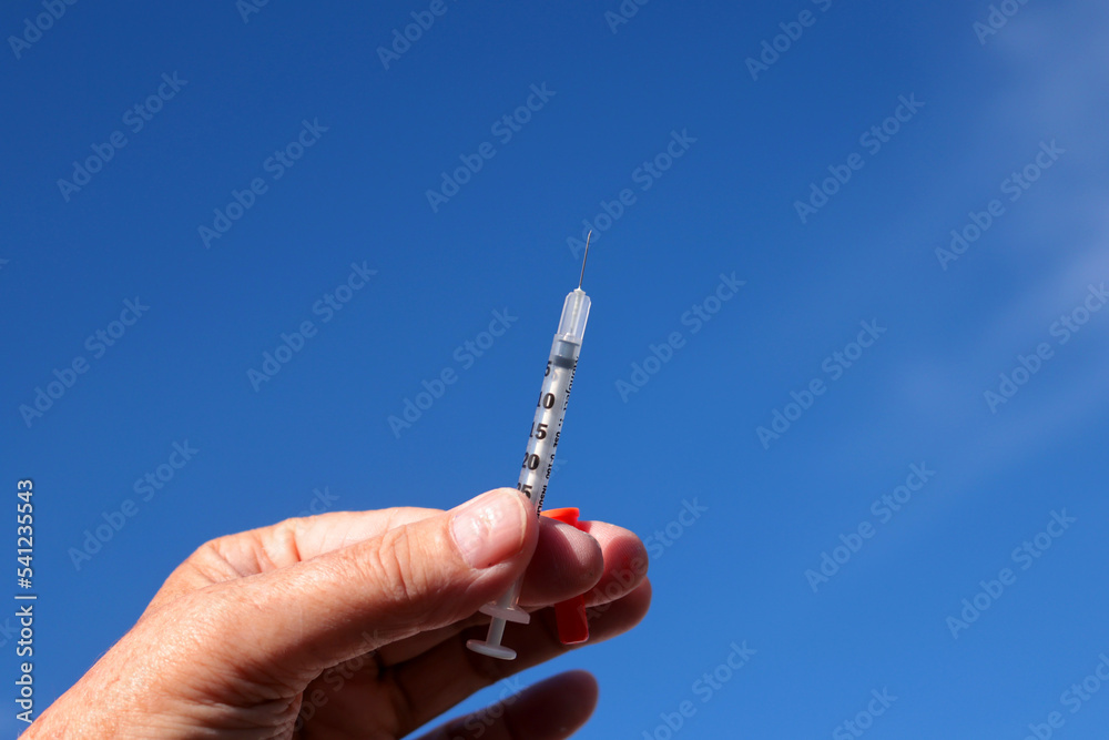 Foto de Stock hand holding syringe package, unpacking it and un capping ...
