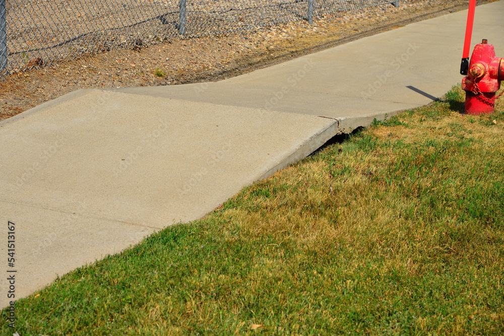 Two concrete slabs have raised causing uneven walking surface, creating ...