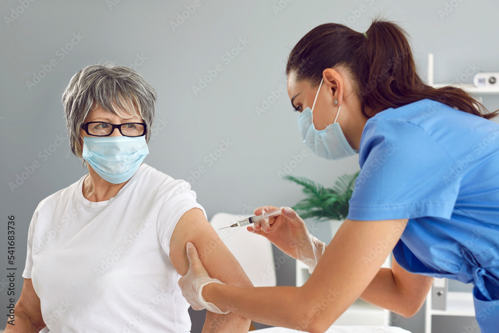 Professional nurse or doctor holding syringe and giving shot to ...