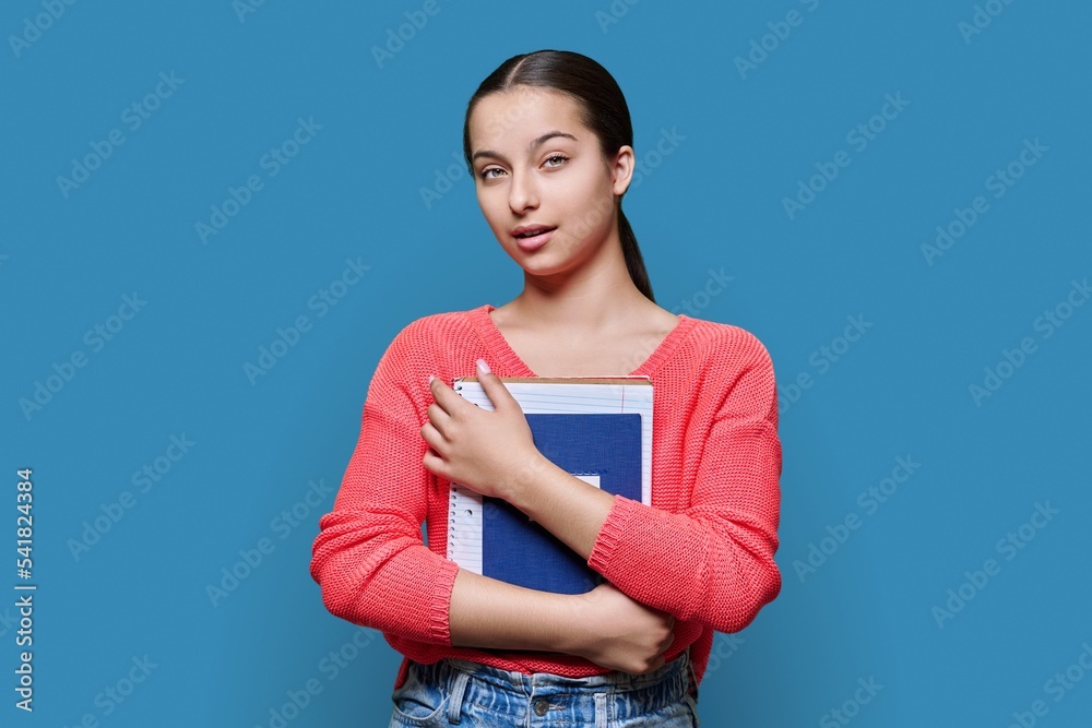 Portrait of teenage high school student on blue color studio background ...
