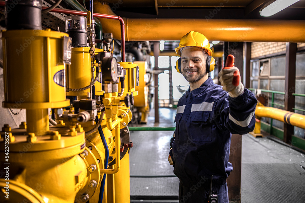 Power generation plant worker controlling crude oil and gas processing ...