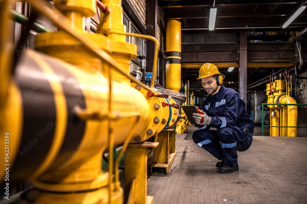 Industrial technician checking gas pipeline installations inside ...