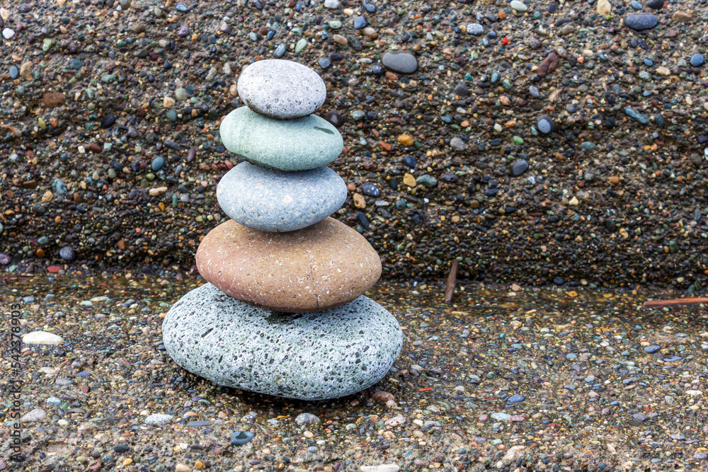Pyramid of stones against the background of a weathered concrete wall ...