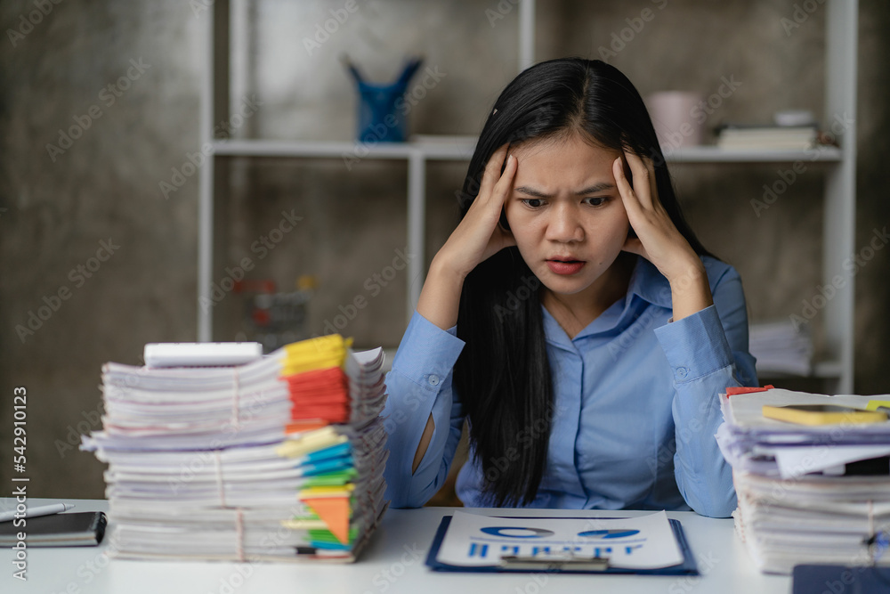 Asian female worker working overtime in the office late at night The ...