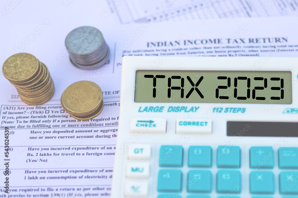 Tax 2023 text on calculator screen, with stack of coins and ITR Indian ...