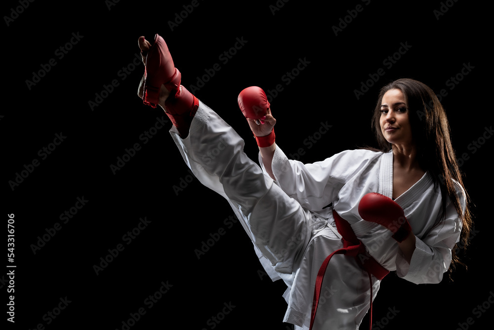 girl exercising karate leg kick wearing kimono and red gloves against ...