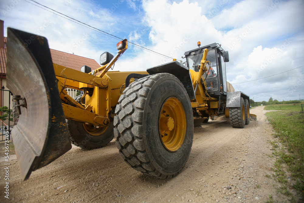 Road grader bulldozer, leveling the settlements on the road Stock Photo ...