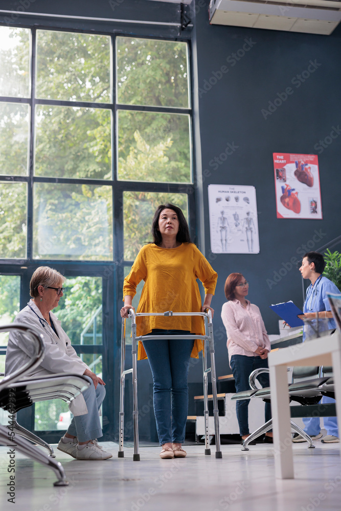 Senior physician attending physiotherapy with injured patient, doing ...